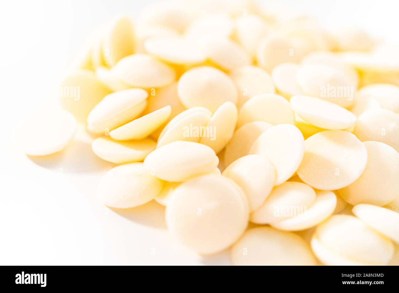 White round chocolate chips for melting chocolate shapes on a white ...