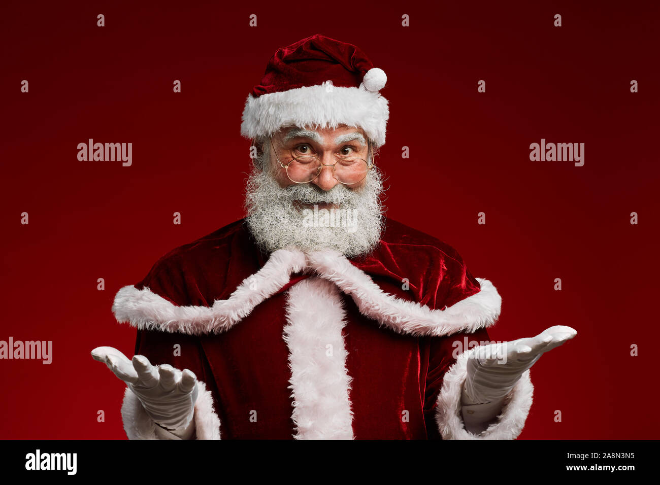 Waist up portrait of smiling Santa Claus welcoming guests holding arms ...