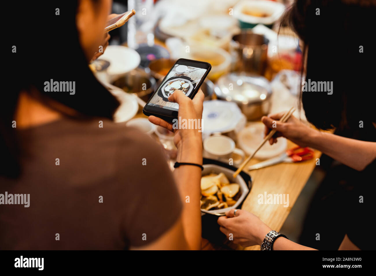Female Friends having dinner party taking picture of food post on ...