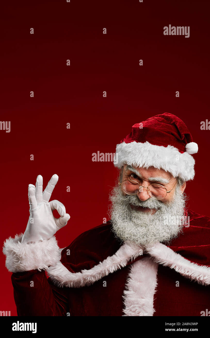 Waist up portrait of winking Santa Claus looking at camera and showing ...