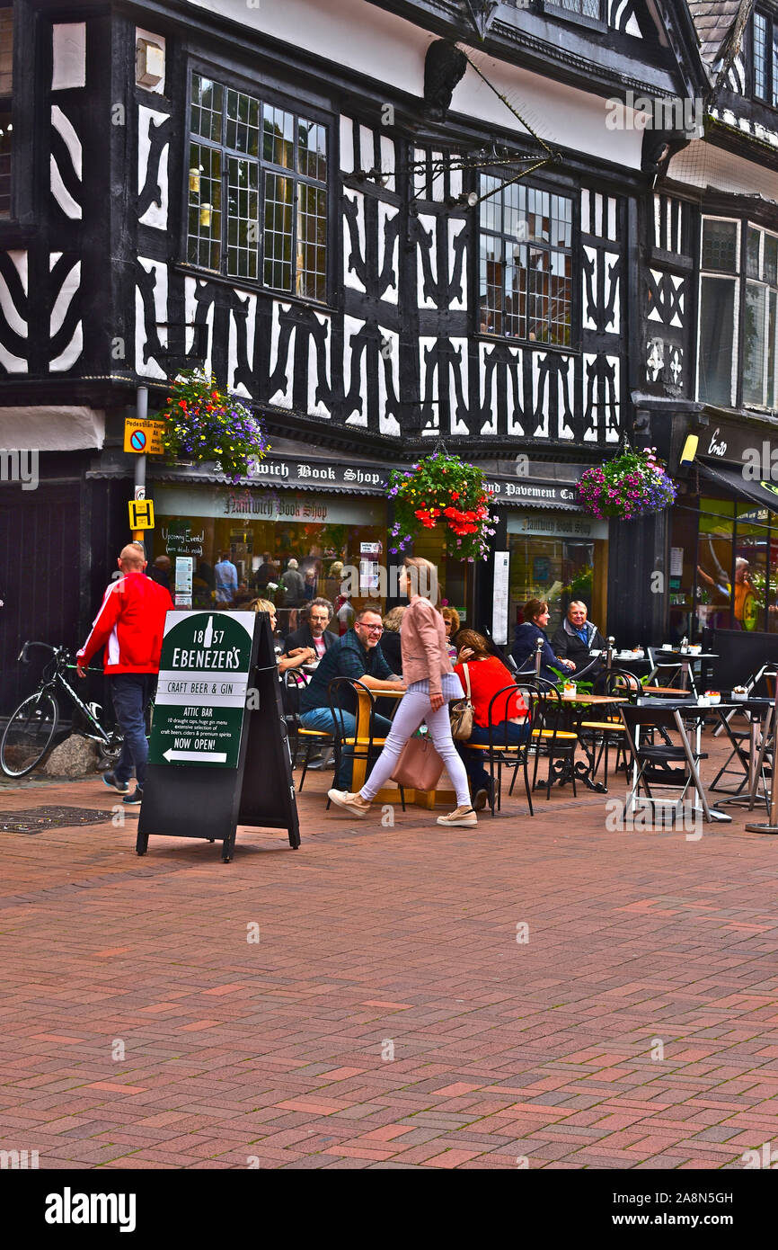 A busy scene in the historic Nantwich town square with people passing ...