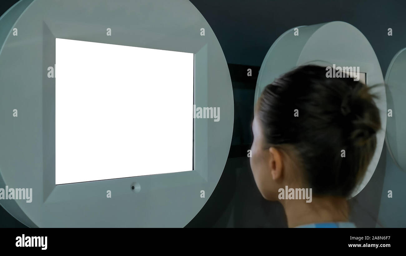 White screen concept - woman looking at blank white display wall at ...