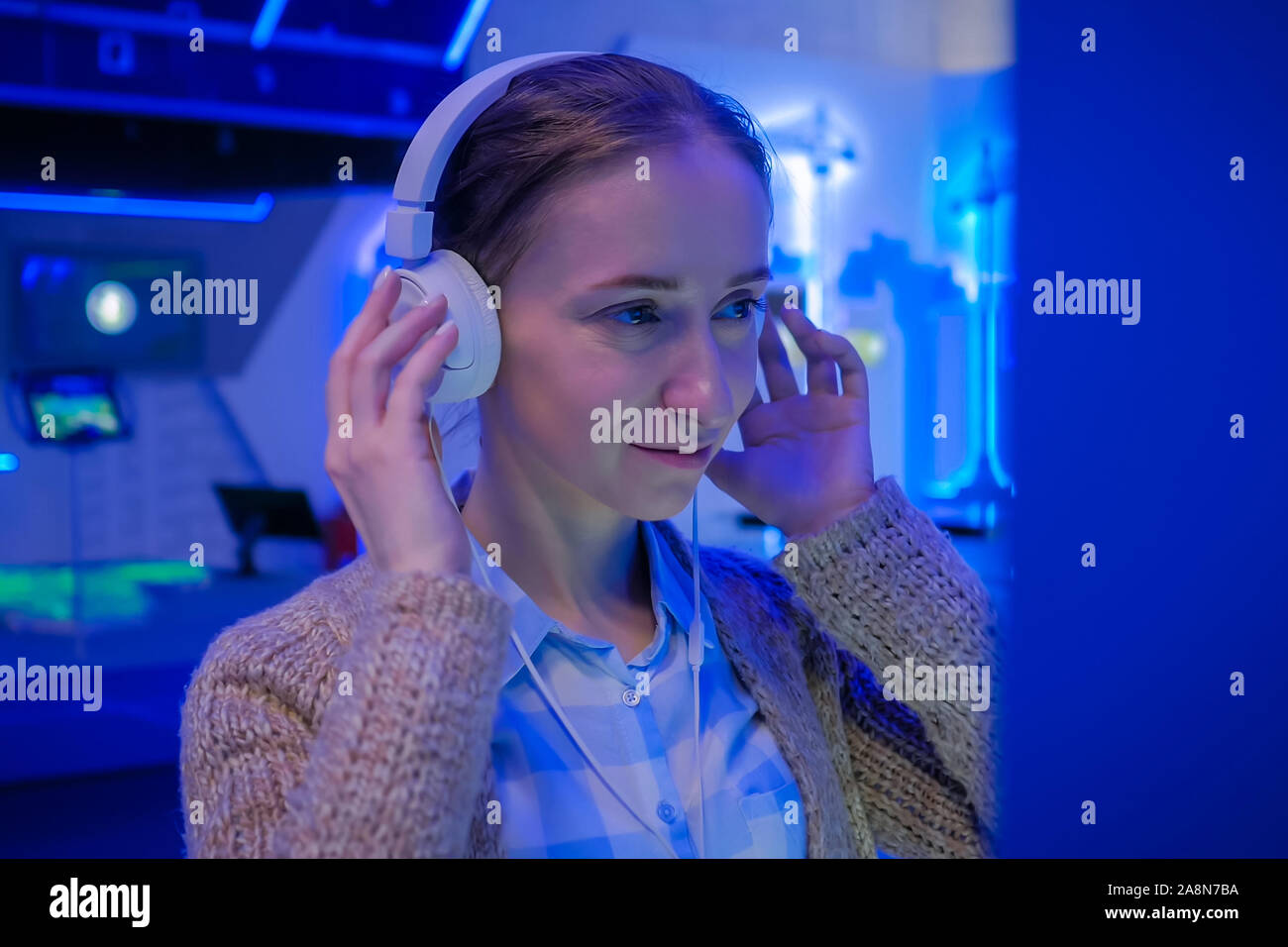 Woman looking at exposition and listening audio guide at exhibition ...