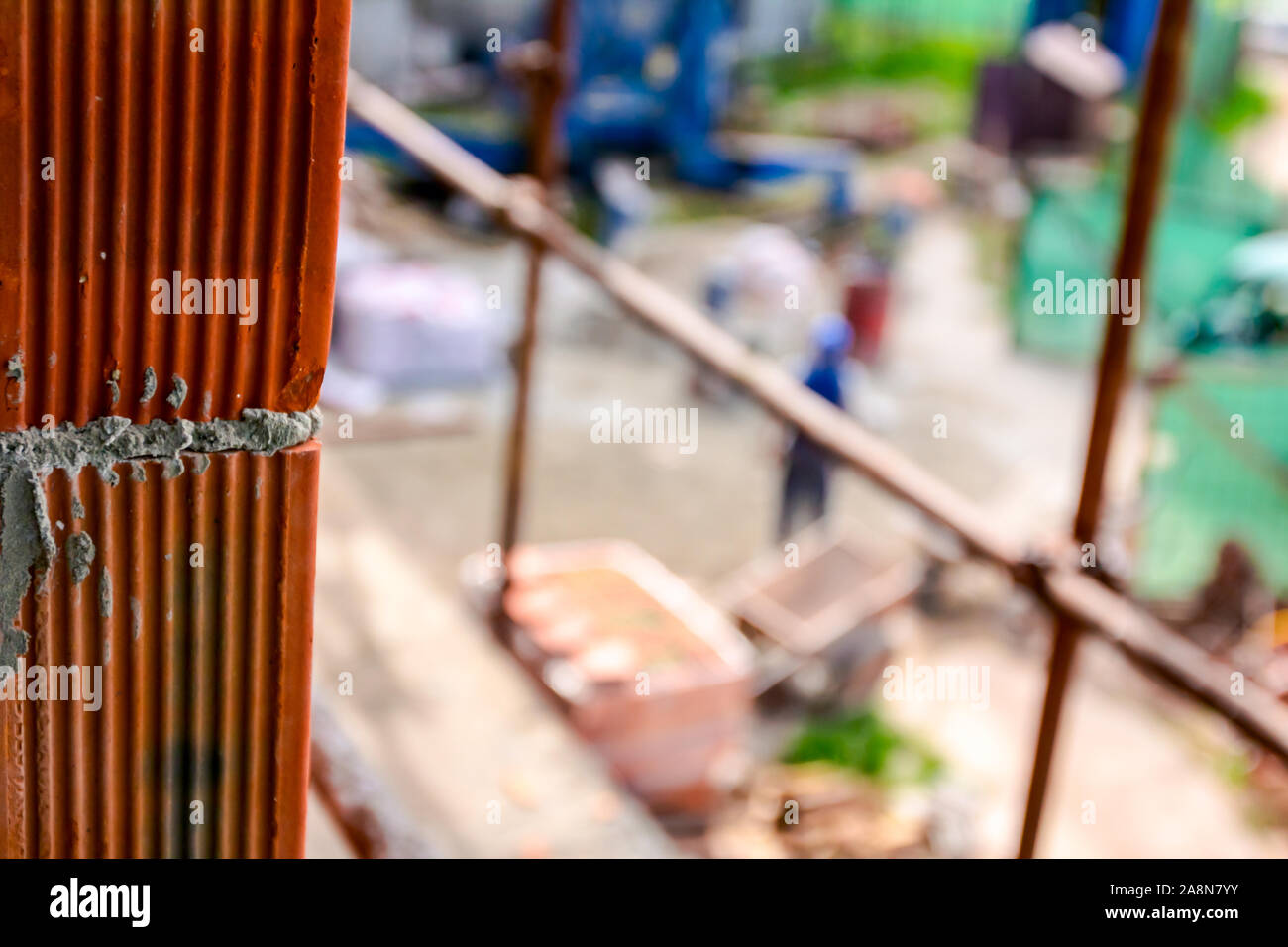 View on wall edge with red blocks and mortar with rusty scaffold with ...