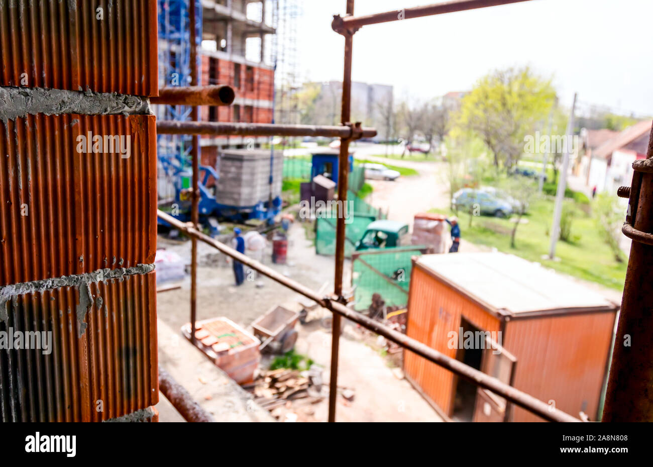 View on wall edge with red blocks and mortar with rusty scaffold with ...