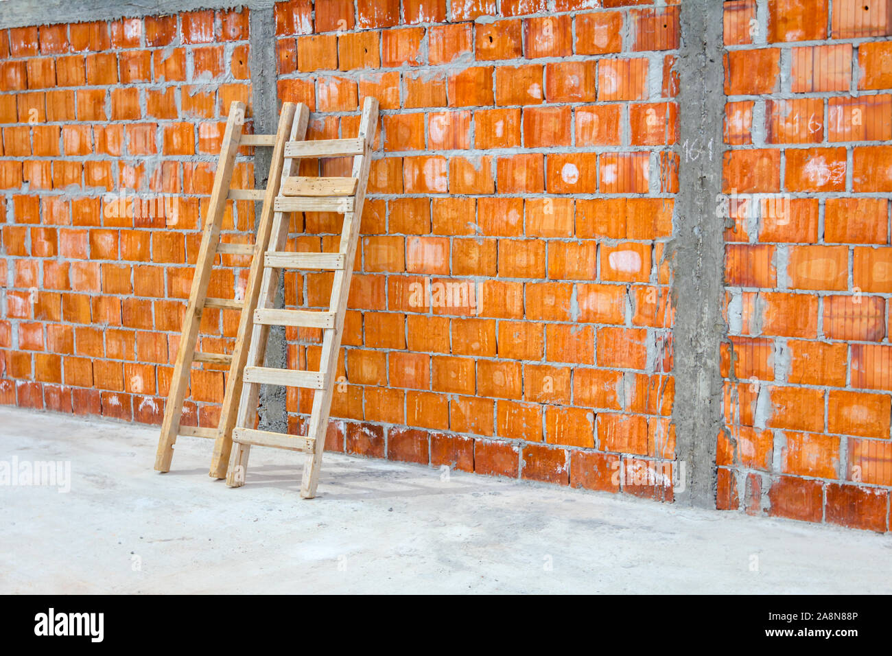Front view on used wooden ladders, leaning against the wall for access ...