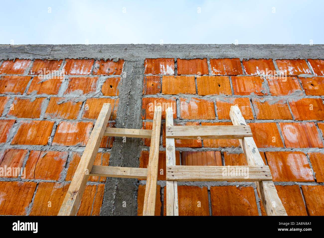 Front view on used wooden ladders, leaning against the wall for access ...