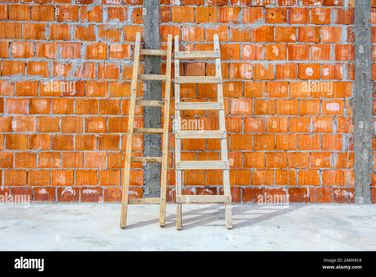 Front view on used wooden ladders, leaning against the wall for access ...