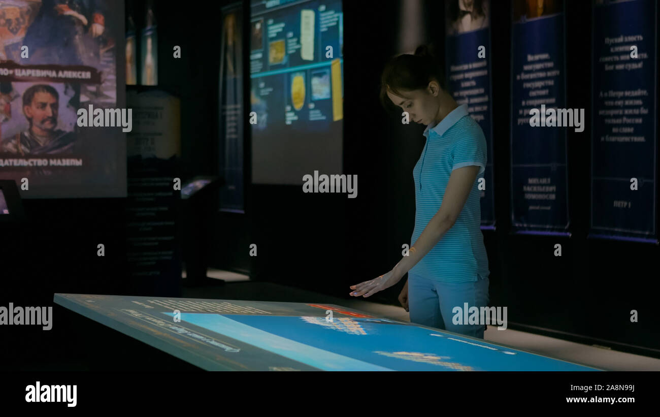 Woman using interactive display at modern history museum Stock Photo ...
