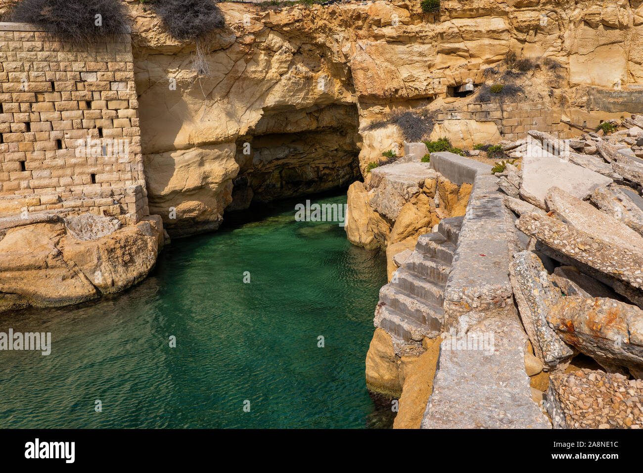 Sea cave with steps to the water, old waterfront below Sliema town in ...