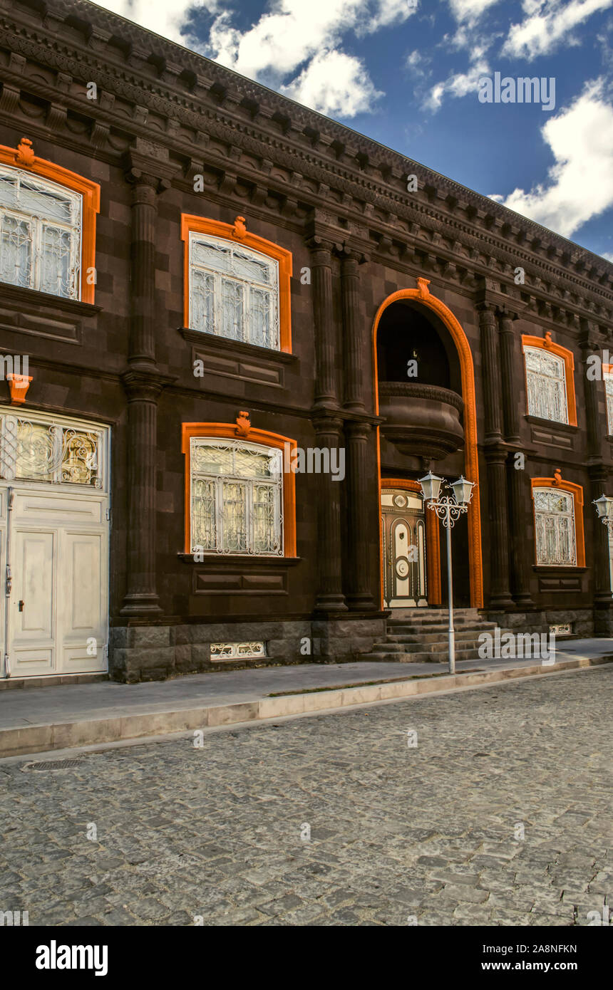 Side view of the house with columns and a carved cornice of black tuff ...