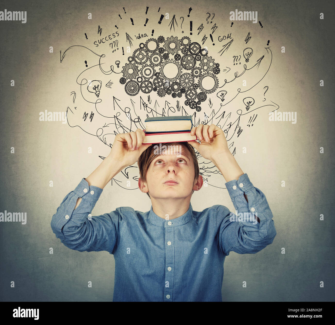 Student boy looks up curious as holds two books on his head, feeling ...