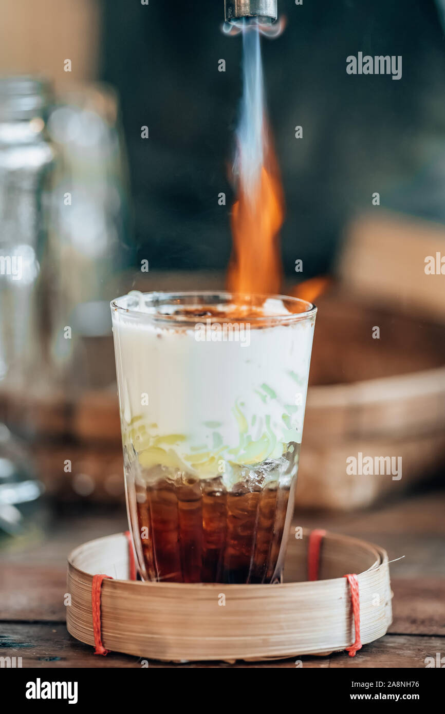 Caramelizing sugar with fire on top of traditional thai dessert called ...