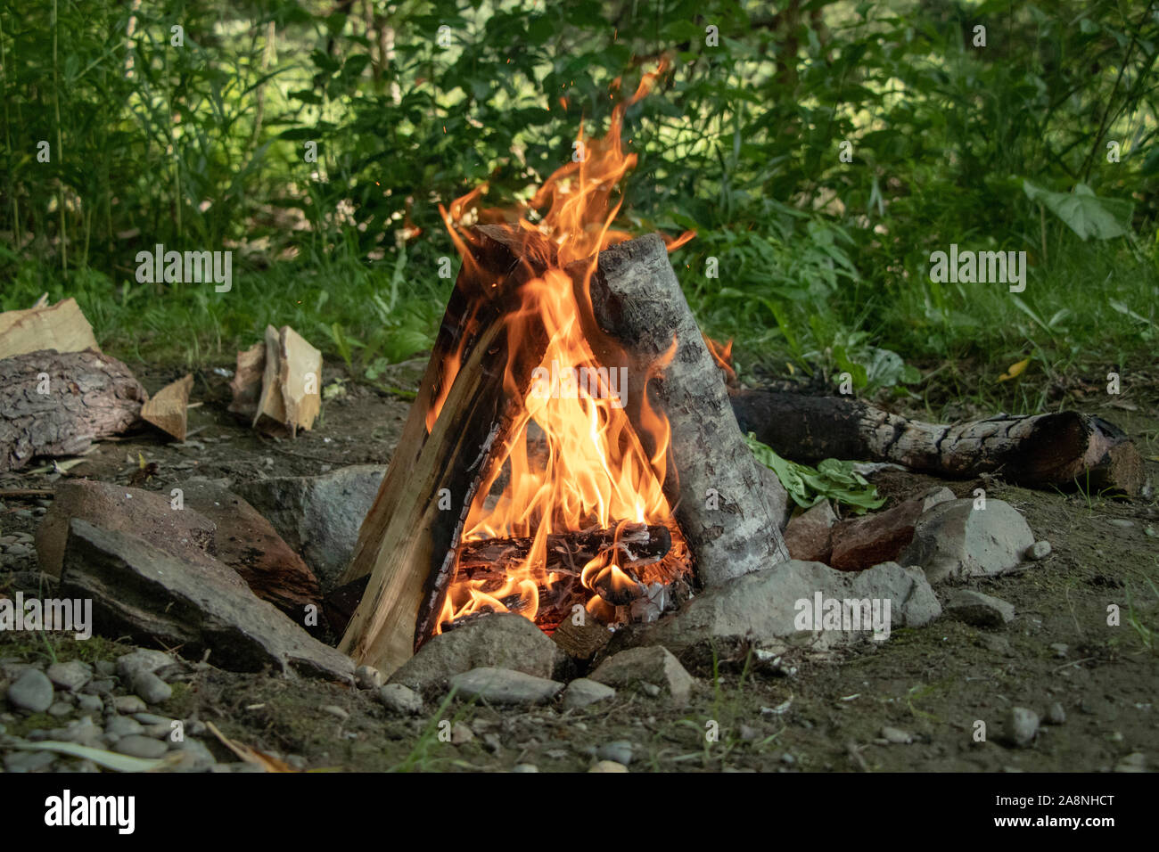 Campfire bonfire logs burning in a stone circle Stock Photo - Alamy