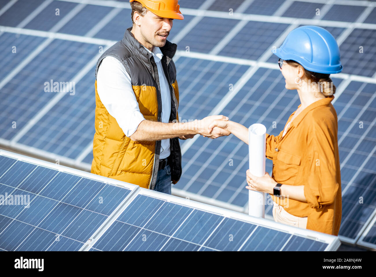 Two successful engineers or architects having a deal, shaking hands ...