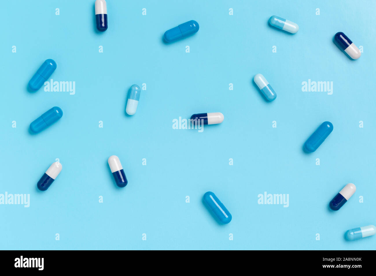 Blue drug capsules on a blue color background Stock Photo - Alamy