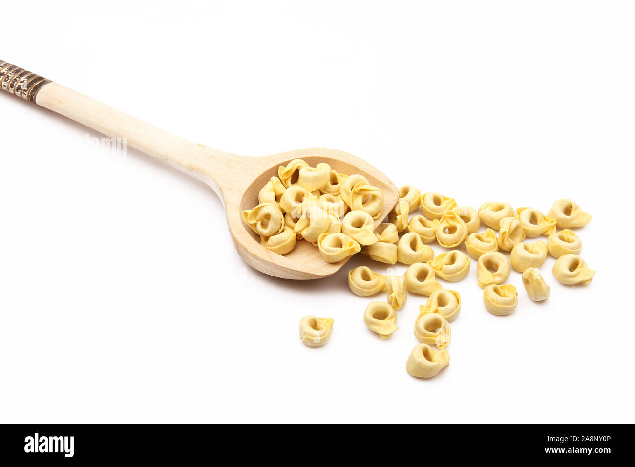 wood spoon with italian raw pasta on white background Stock Photo - Alamy