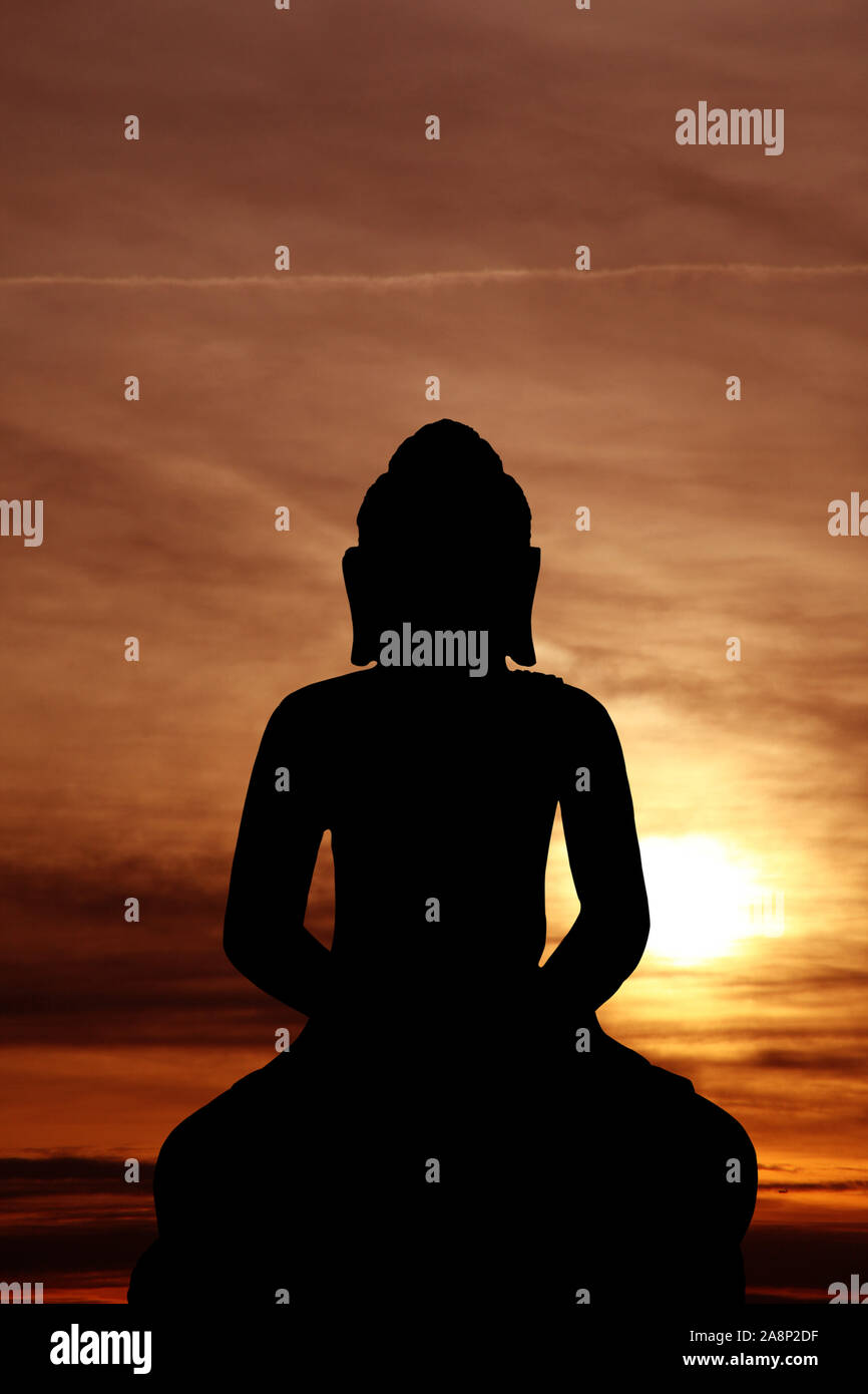 Statue of Buddha on sunset background Stock Photo - Alamy