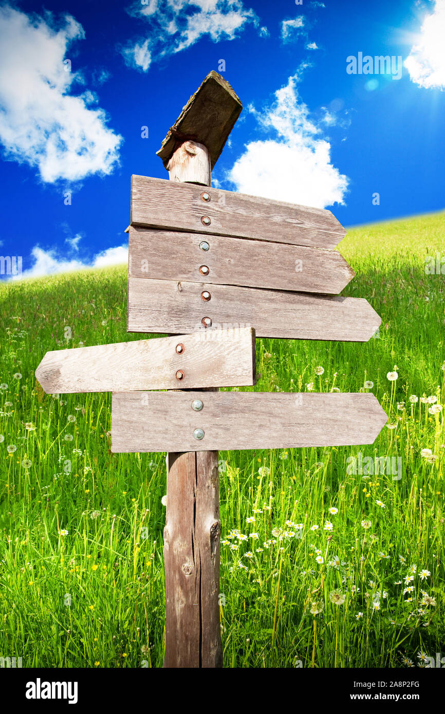 directional wooden arrows on nature background Stock Photo - Alamy