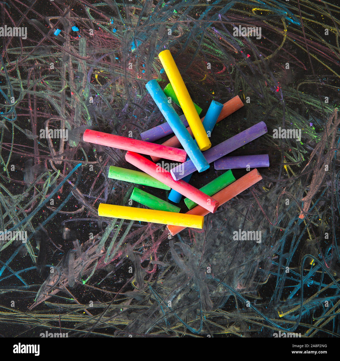 coloured chalks on black background Stock Photo - Alamy