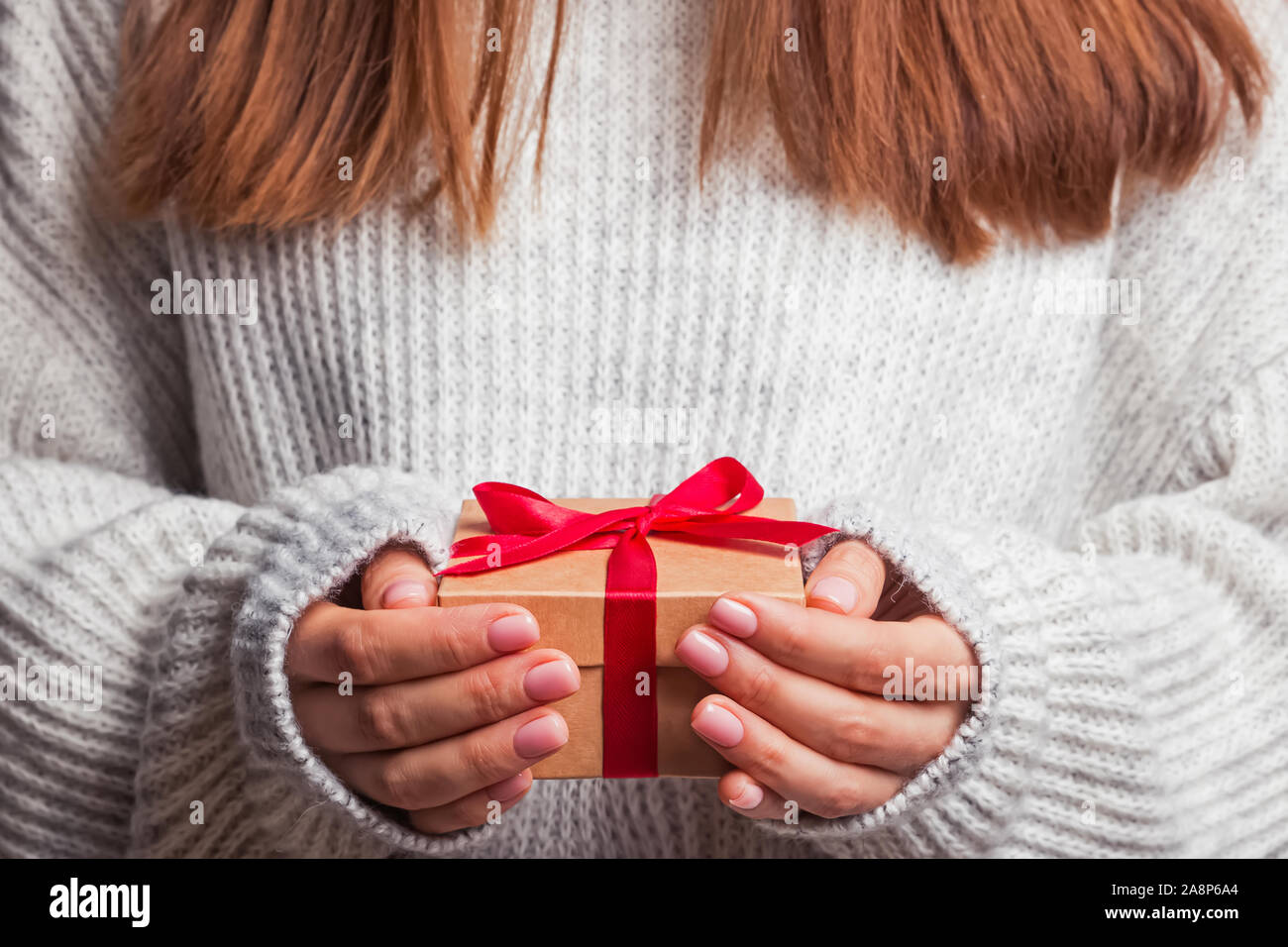 Female hands holding gift box with red ribbon close-up Stock Photo - Alamy