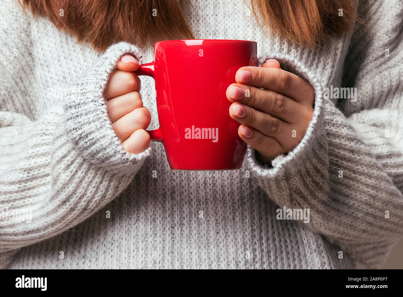 Picture of a woman's hand holding a red coffee mug Stock Photo - Alamy