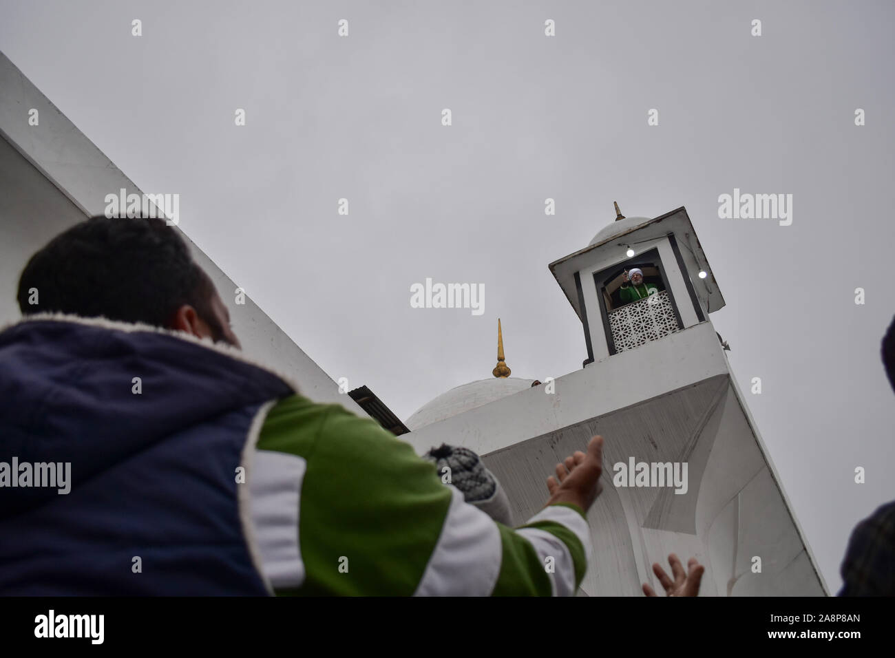 A Kashmiri Muslim prays as a priest displays the holy relic believed to ...