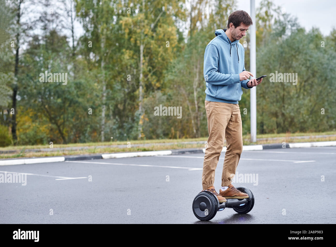 Man riding on hoverboard and using smartphone outdoor Stock Photo - Alamy