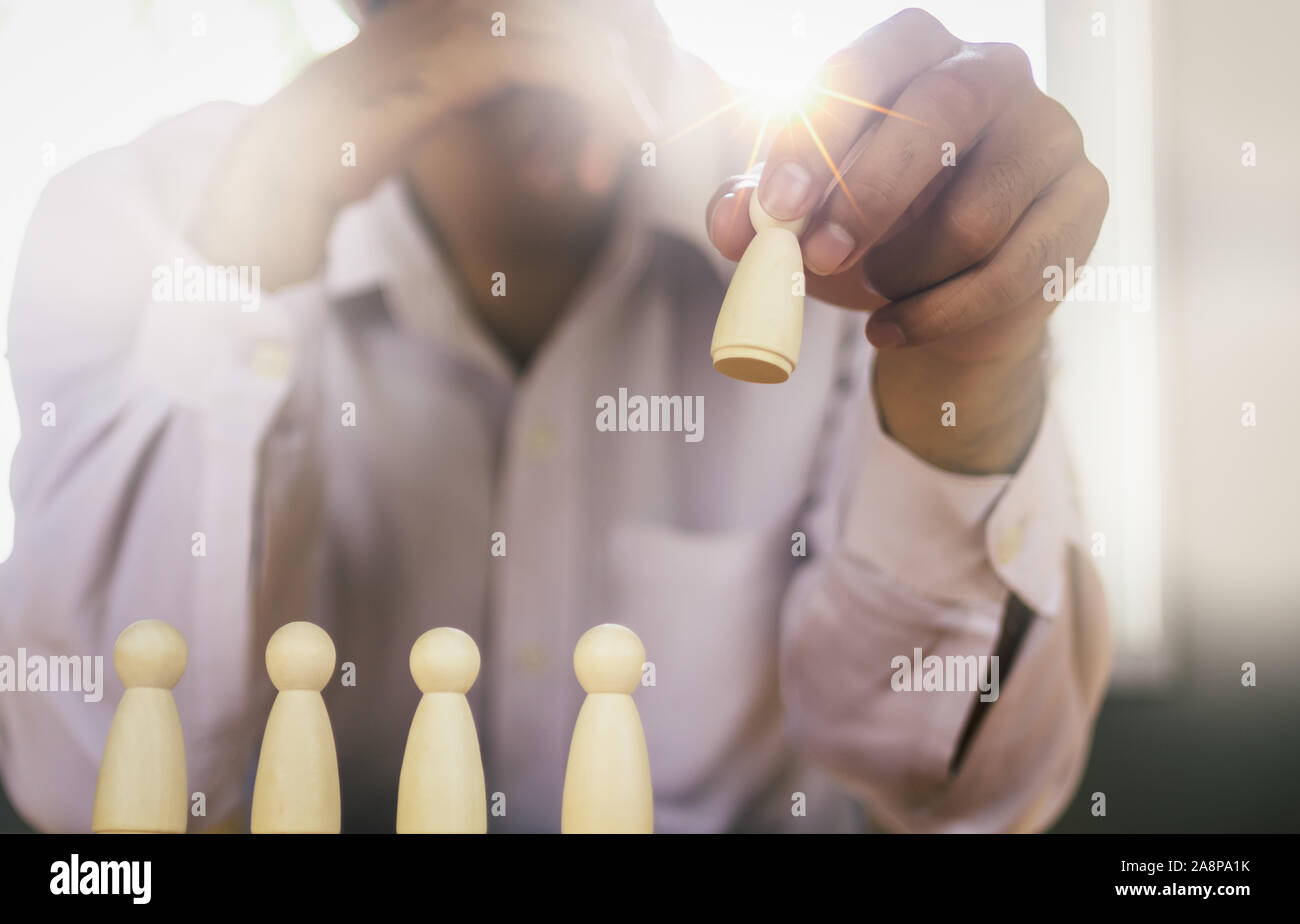 Business and human resource concept, man picks wooden doll from the row ...