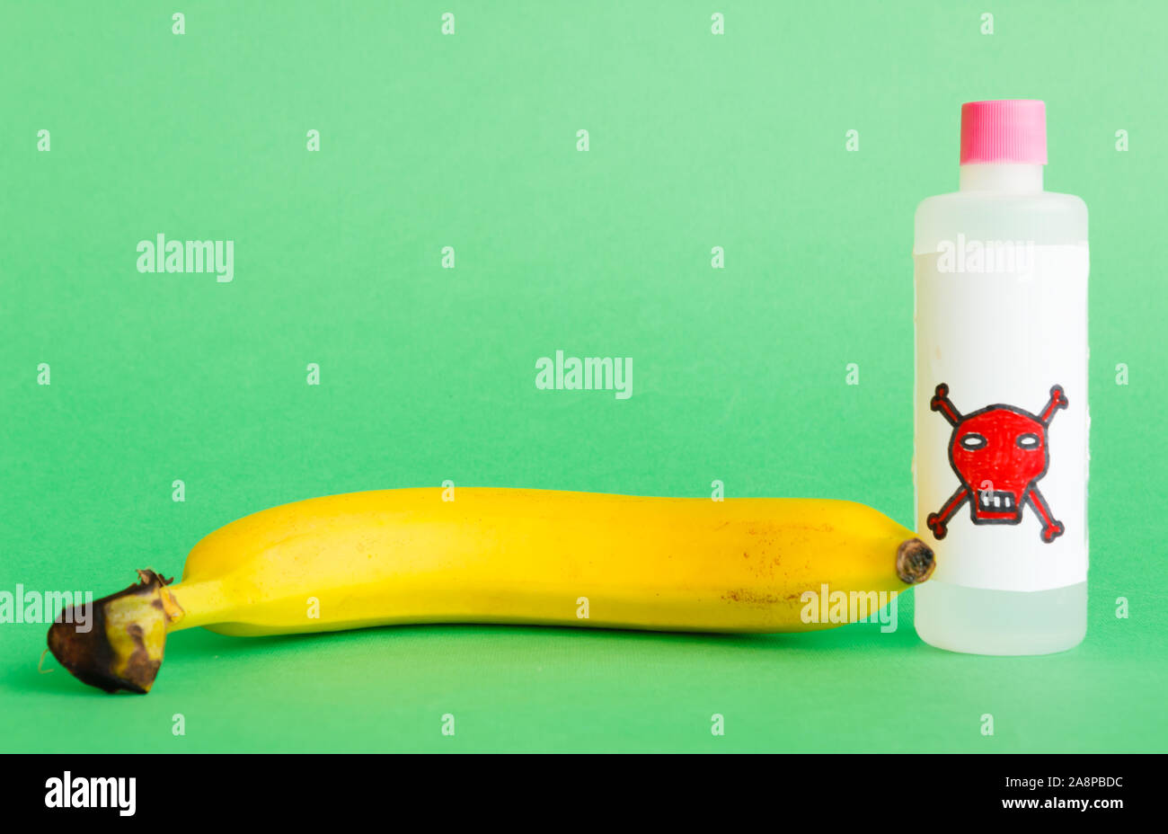 a banana with a bottle that contains pesticide with the symbol of death ...