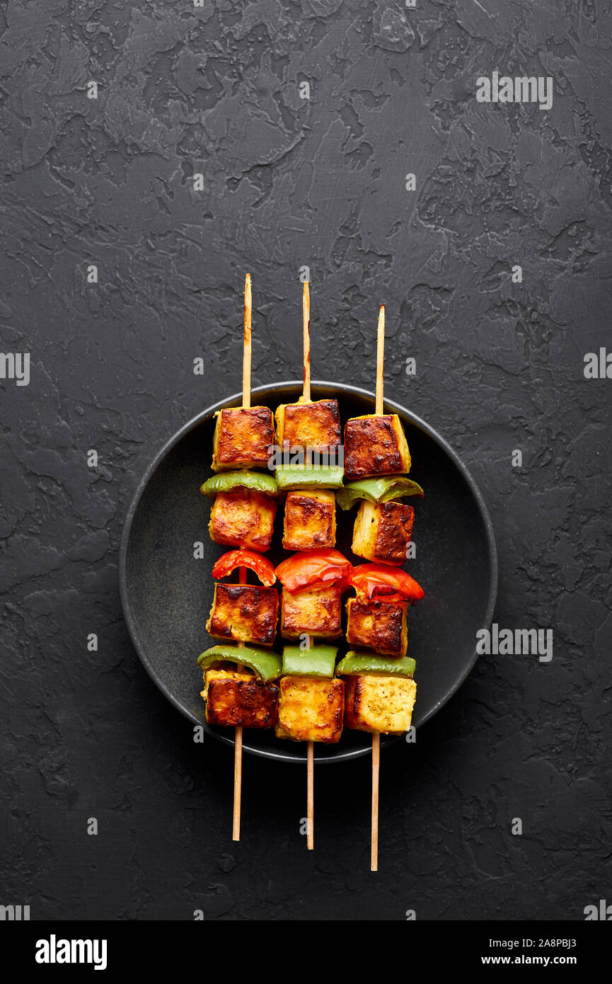 Paneer Tikka at skewers in black bowl at dark slate background. Paneer ...