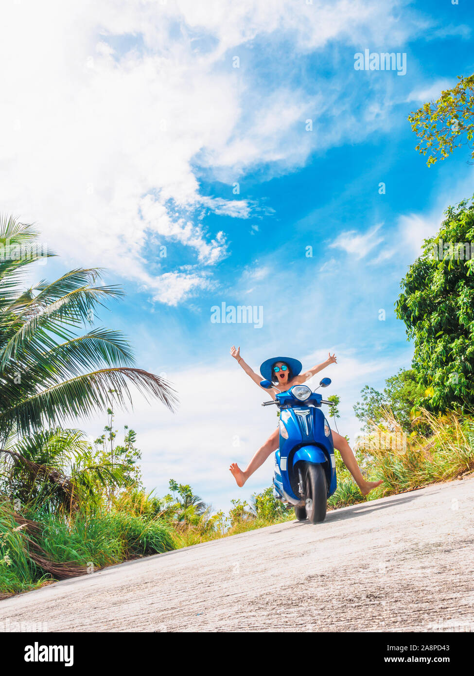 Crazy funny woman with flying hair riding a motorbike on a blue sky and ...