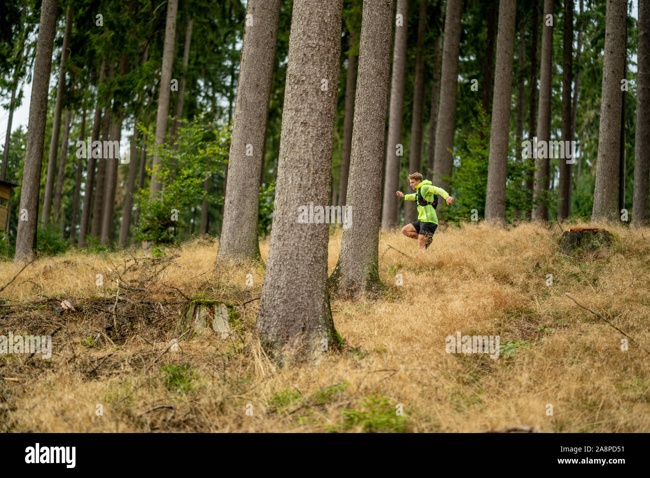 A young athlete in barefoot shoes runs down the mountain. Mountain run ...