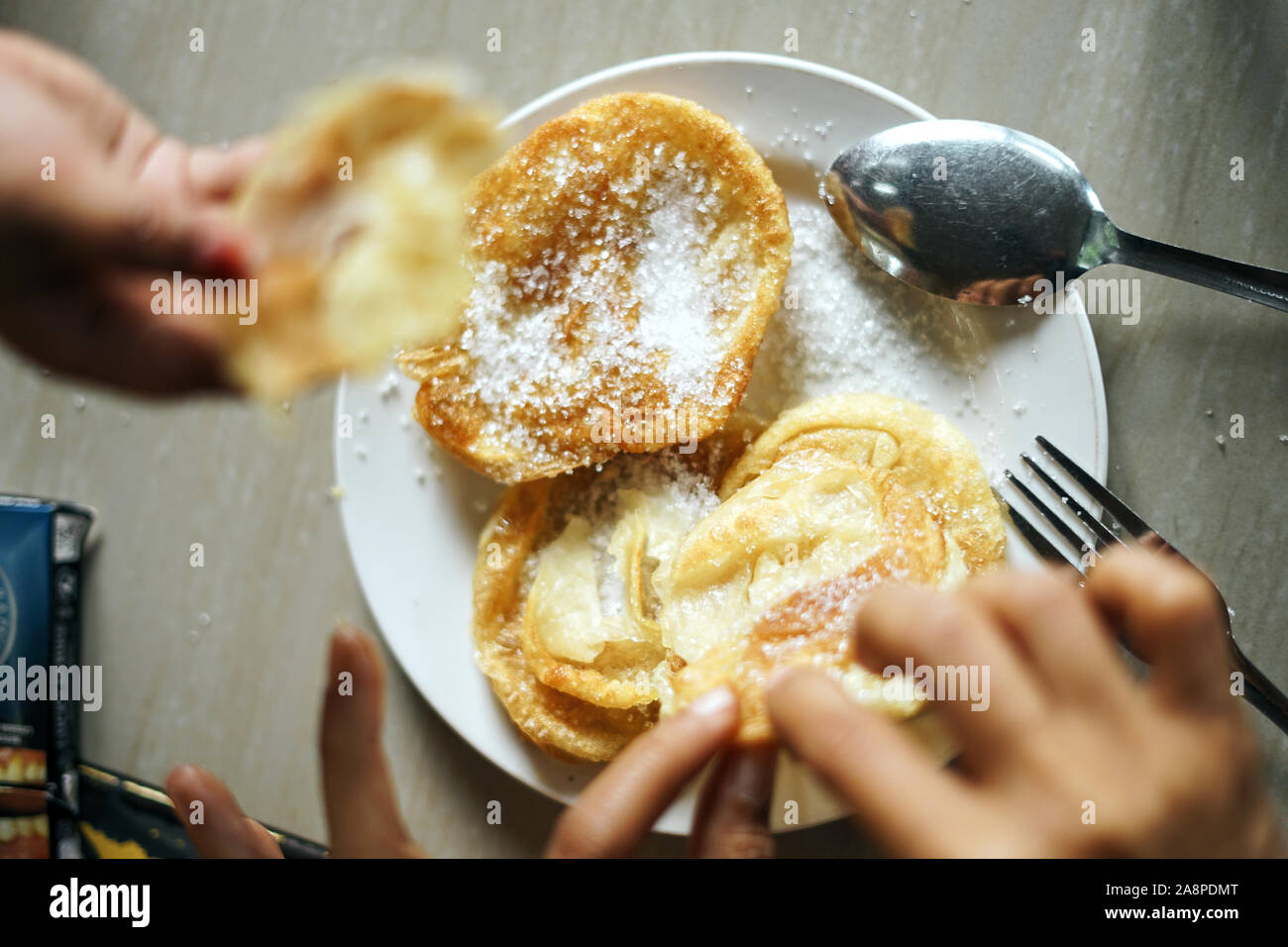 Child hand holding Roti Canai or chapati at traditional street food ...
