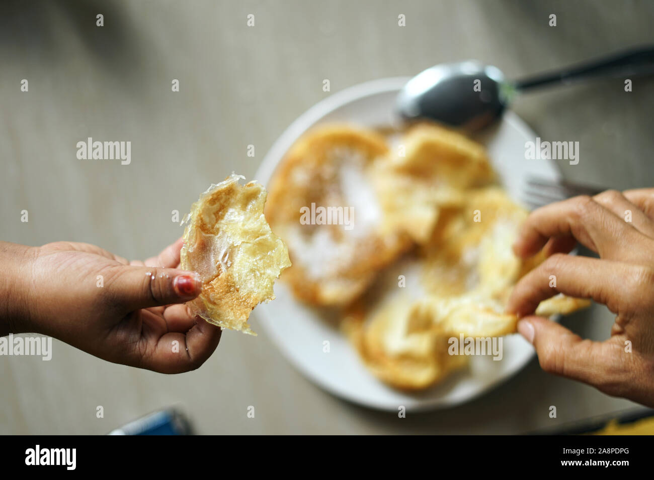 Child hand holding Roti Canai or chapati at traditional street food ...