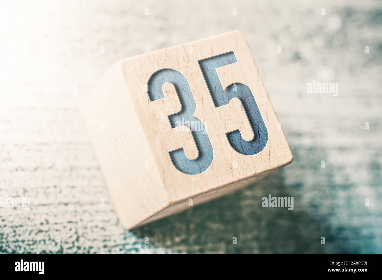 The Number 35 On A Wooden Block On A Table Stock Photo - Alamy