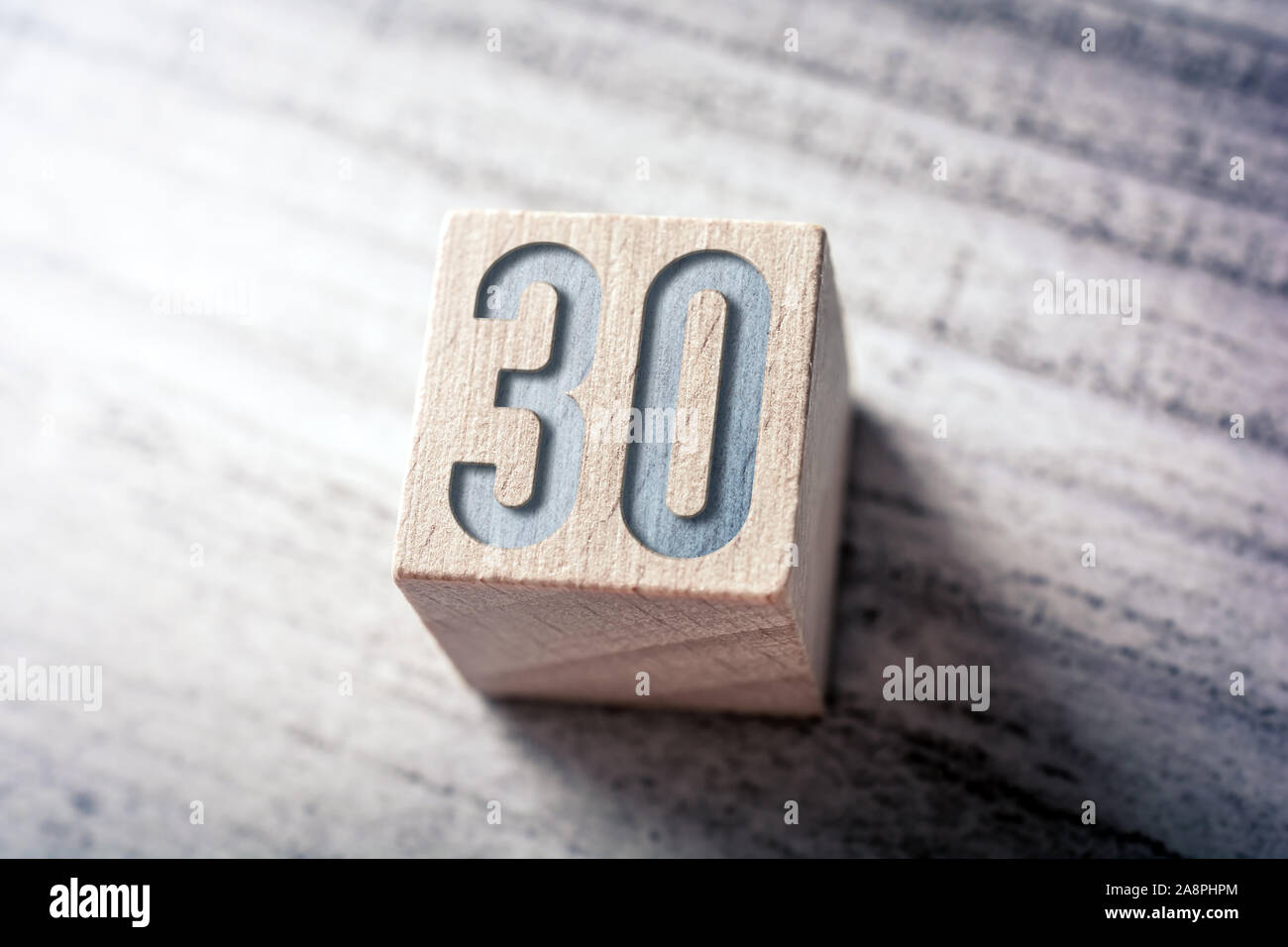 The Number 30 On A Wooden Block On A Table Stock Photo - Alamy