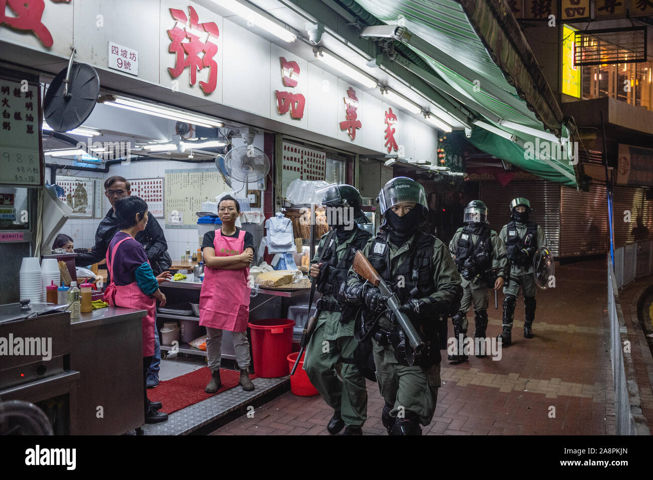 Restaurant staff watch as riot police conduct a dispersal operation ...