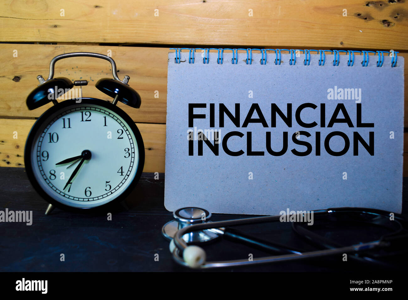 Financial Inclusion write on book isolated on wooden table. Medical or ...