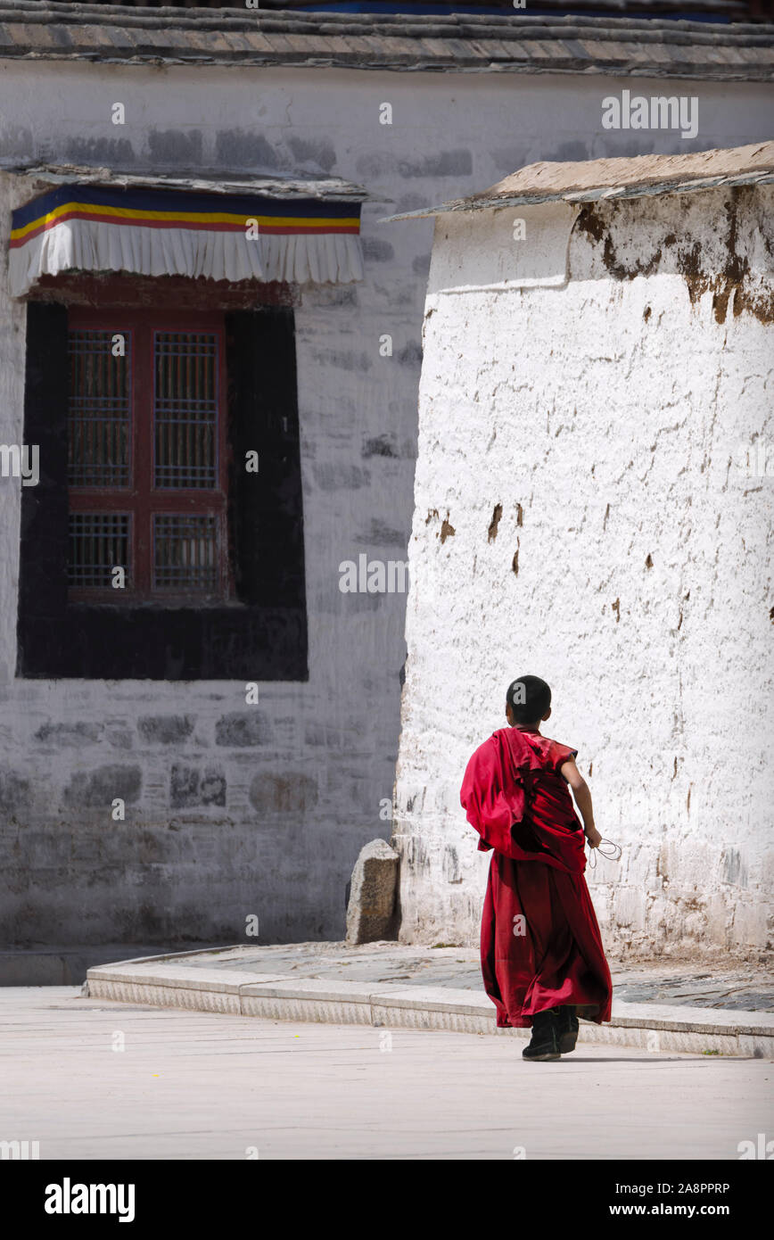 A novice monk running at the streets of Labrang Monastery, China Stock ...