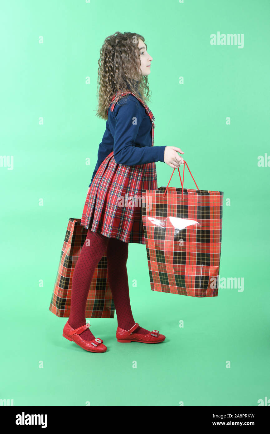 Child with a red packet isolated on green background. Little beauty ...