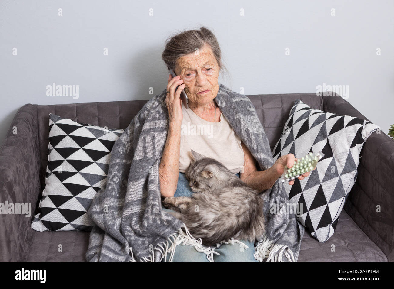 Sick senior woman taking medicine at home. Senior woman talking on ...