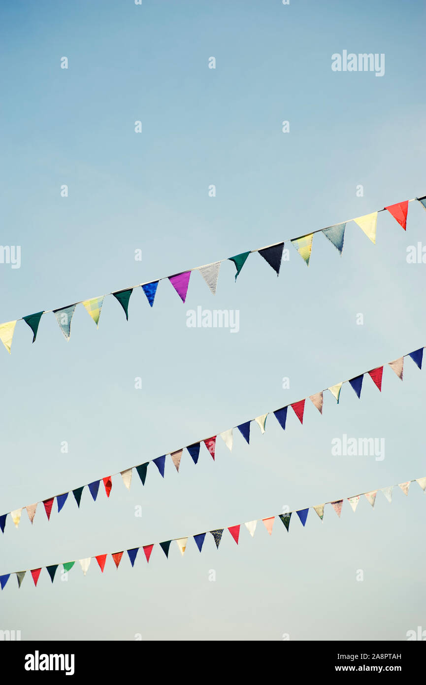 Strings of pennant flags in a variety of colors fluttering in soft ...