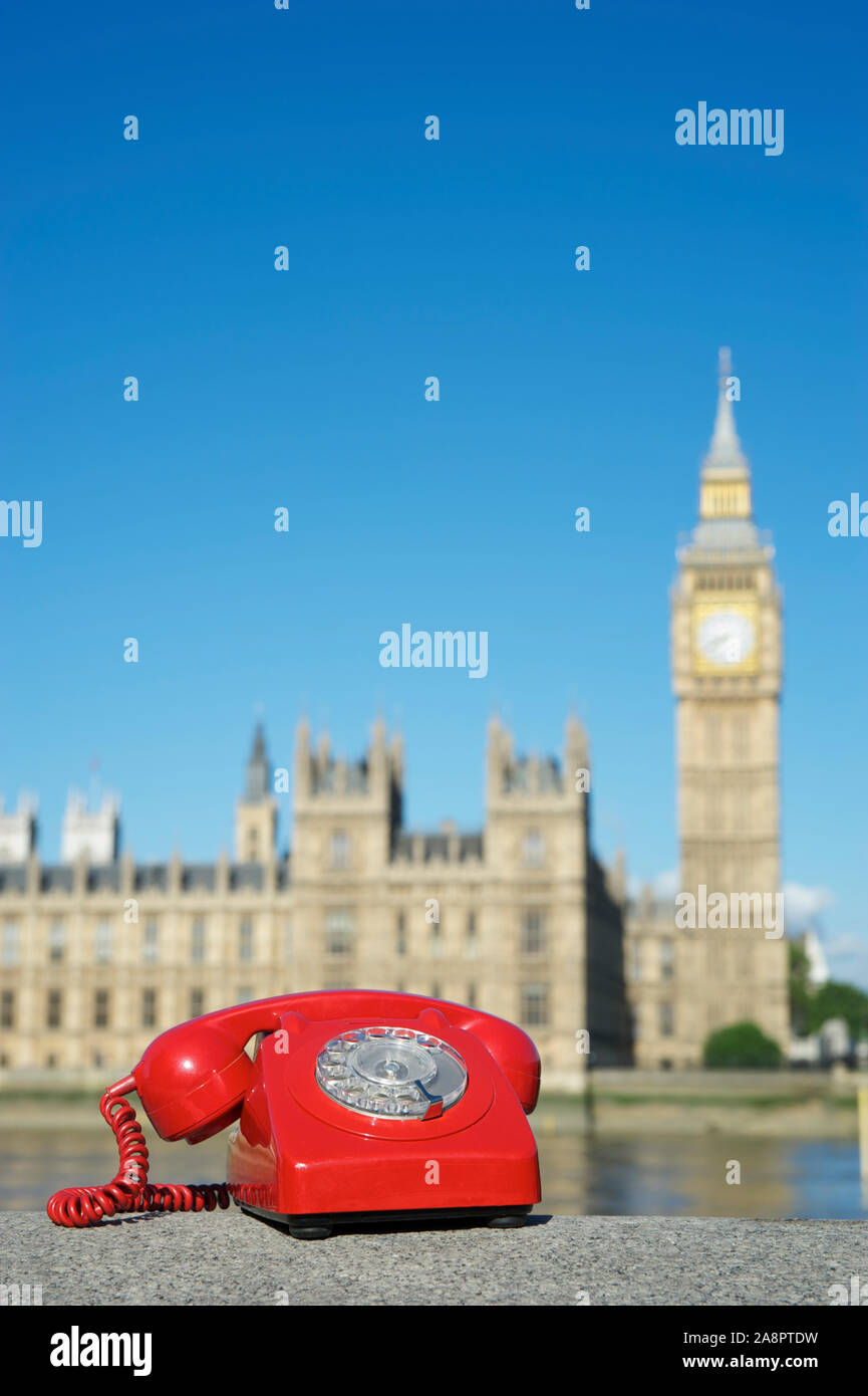 Old-fashioned red rotary dial hotline telephone in front of the Houses ...