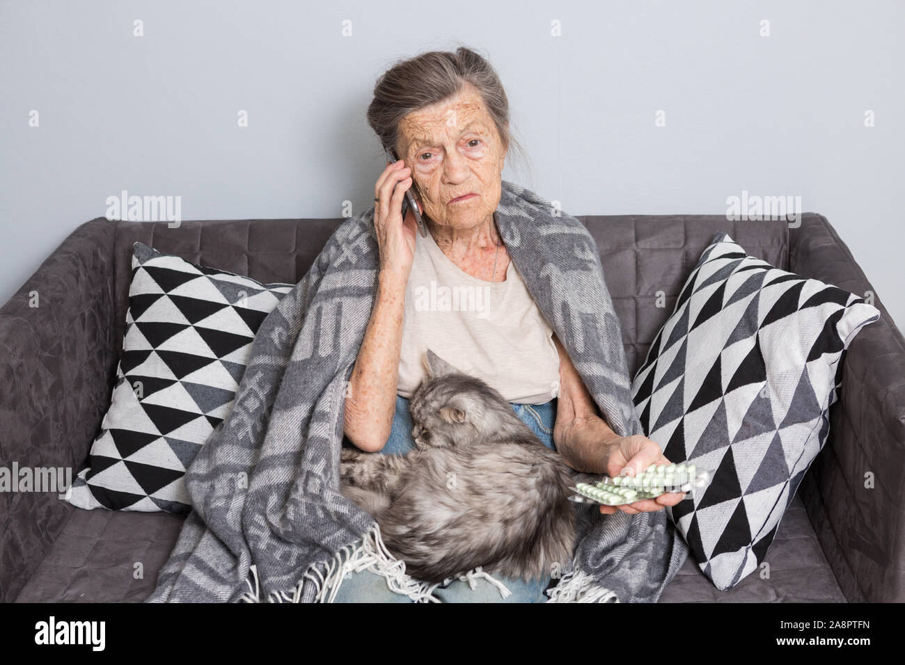 Sick senior woman taking medicine at home. Senior woman talking on ...