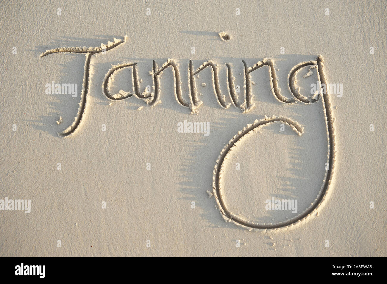 Tanning message handwritten in textured lettering in smooth sand Stock ...