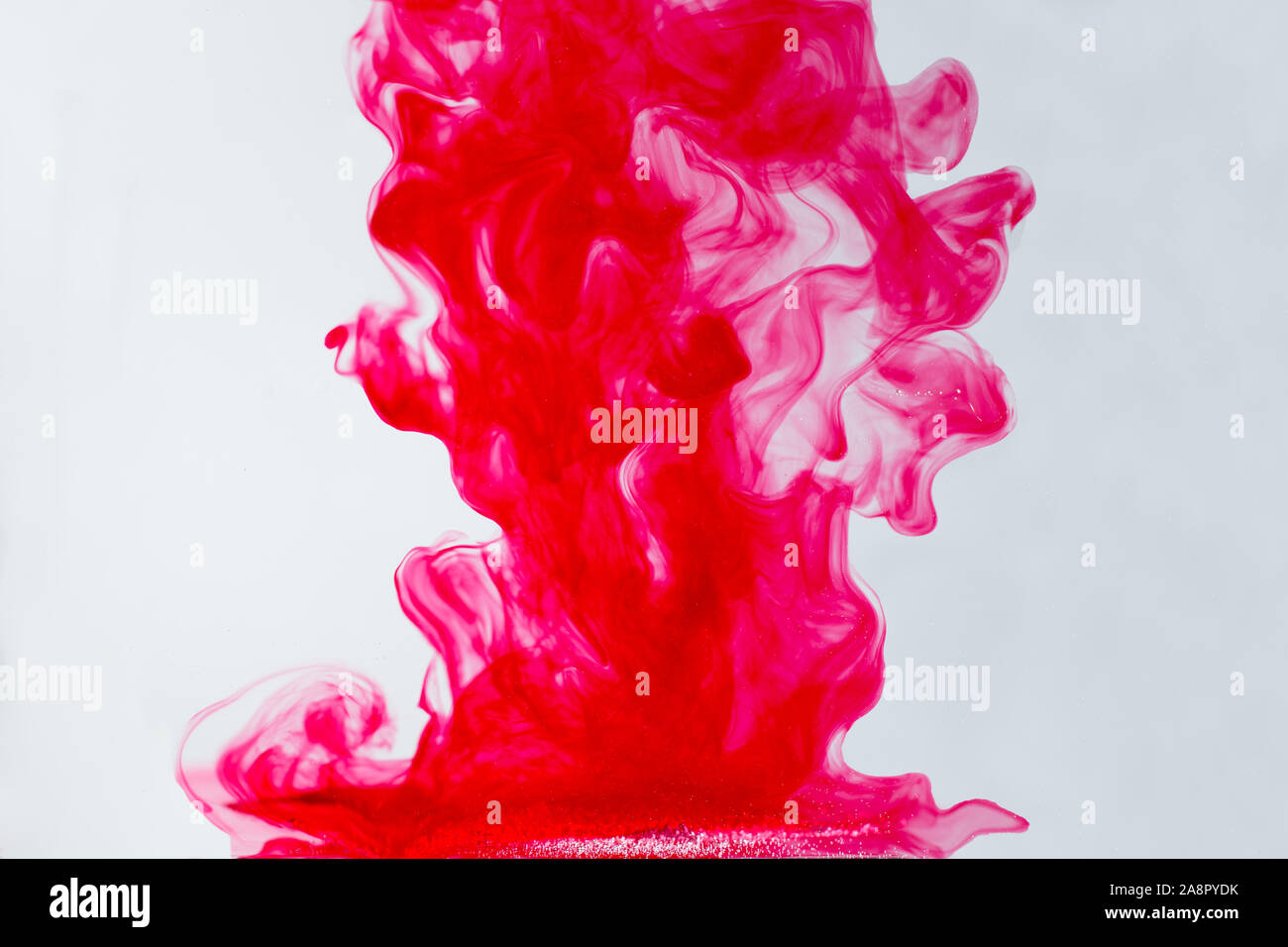 Waves of red ink in water on white background Stock Photo - Alamy