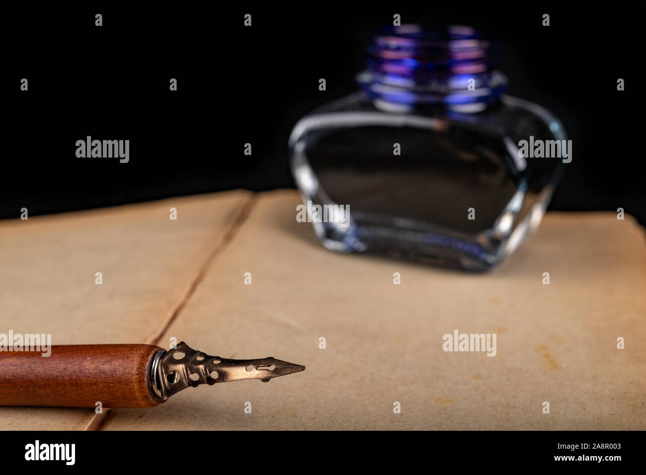 Blue ink, pen and old book. A place to write texts for the writer. Dark ...