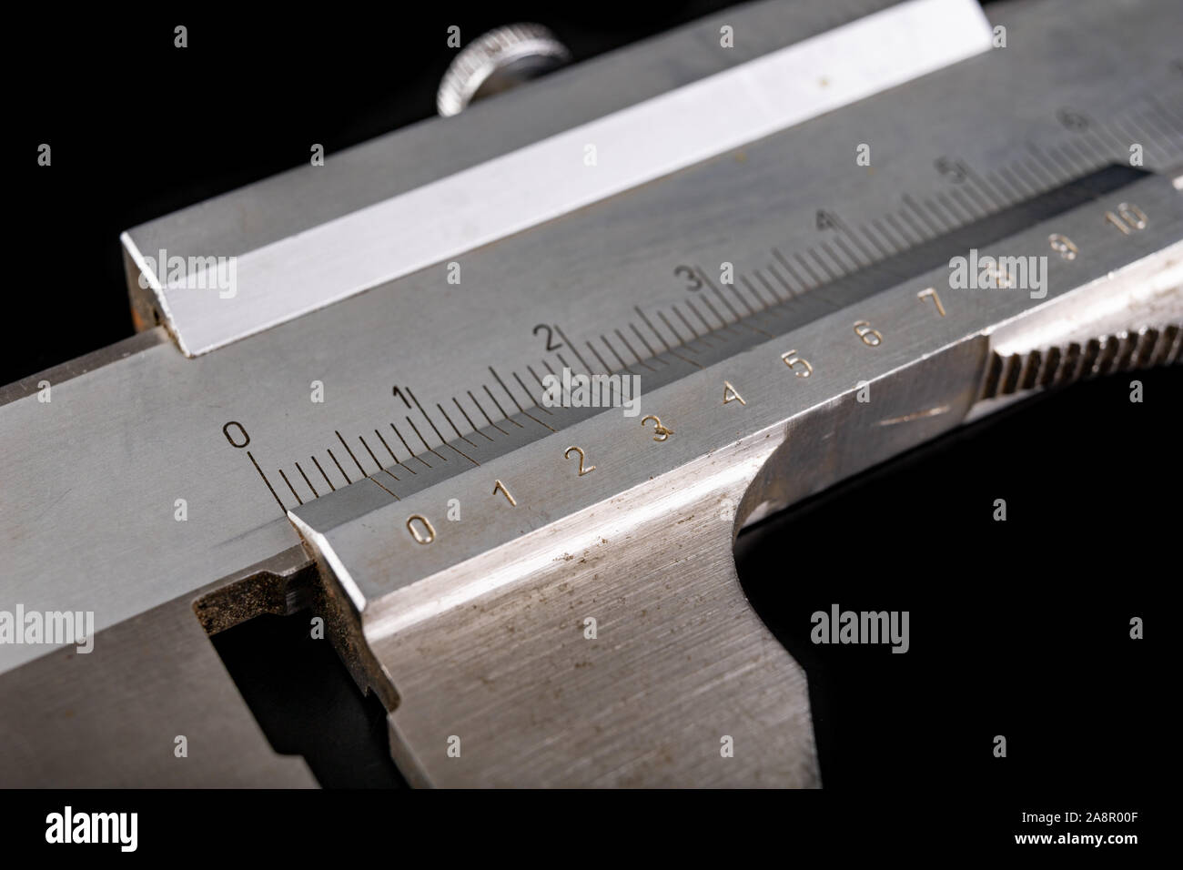 Caliper on a dark workshop table. A tool for precise measurement in the ...