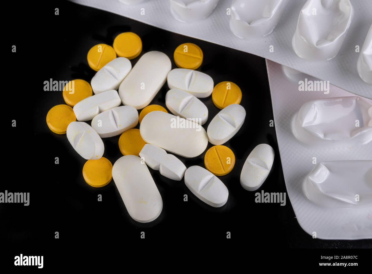 Medical tablets and tablet packaging. Medication on a dark table. Black ...